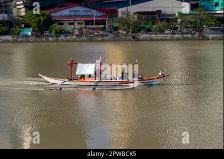 A small boat sailing down the Pasig River, Manila, The Philippines ...