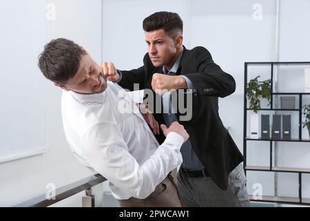 Emotional colleagues fighting in office. Workplace conflict Stock Photo ...