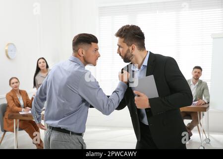 Emotional colleagues fighting in office. Workplace conflict Stock Photo ...
