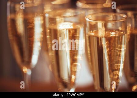 Transparent wineglasses with champagne placed on blurred background of ...