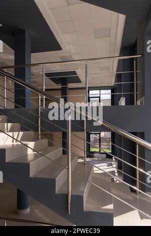 Stairs in a concrete office building in neutral tones, covered with ...