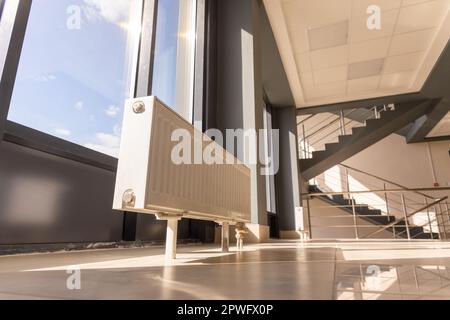 Vertically installed central heating radiator on the floor at the fully ...