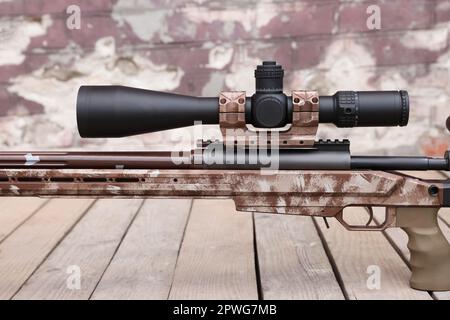 Modern powerful sniper rifle with telescopic sight on camouflage fabric ...
