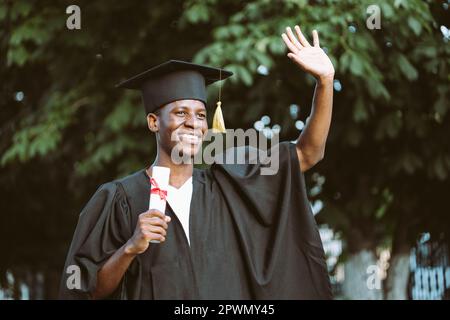 Rejoicing black guy graduate from university bouncing with happiness in ...