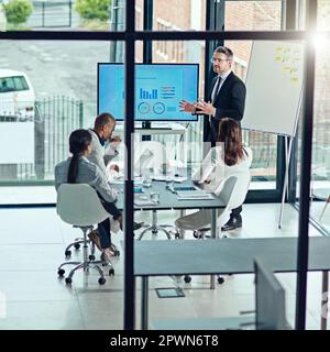Guiding his team to success. a mature businessman giving a presentation ...