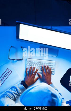 Getting ready for cyber warfare. High angle shot of a young male hacker cracking a computer code ...