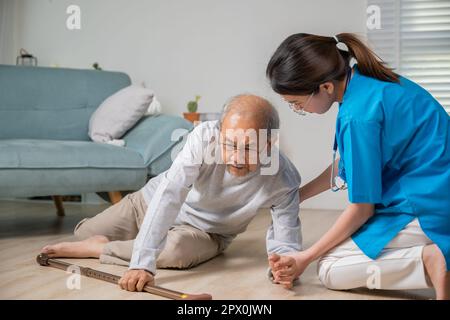 Asian older senior man falling down on lying floor and woman nurse came ...