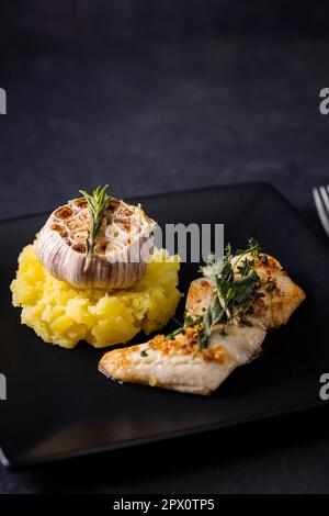 cod fillet with couscous and roasted garlic Stock Photo - Alamy
