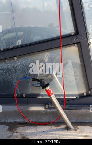 A high-pressure washing gun in a holder at a self-service car wash ...