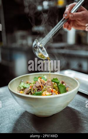 Pouring cooking oil from ladle Stock Photo - Alamy