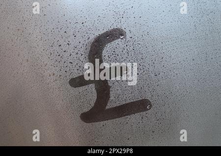 Symbol of English pounds is written with a finger on the surface of the ...