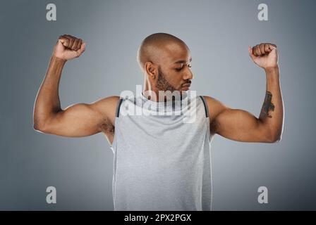 Im strong and thats enough. a sporty young man flexing his muscles ...