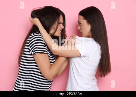 Aggressive young women fighting on light grey background Stock Photo ...