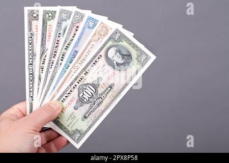 Old Mexican money - Pesos in the hand on a gray background Stock Photo ...