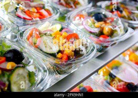 Plastic boxes with pre-packaged vegetable salads, put up for sale in a ...