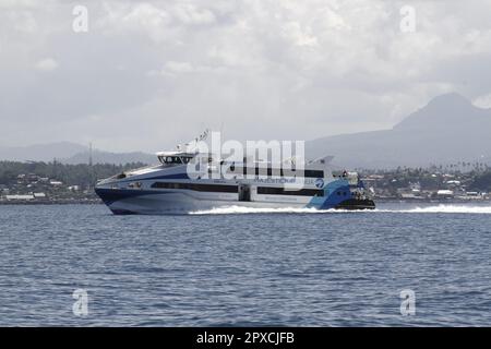 Fast ship sailing with hills in the background Stock Photo - Alamy