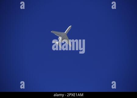 The plane crosses a very blue and clean sky, photographed from below ...