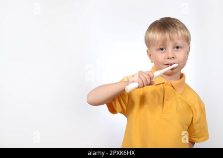 a boy child brushes his teeth with a smart toothbrush Stock Photo - Alamy