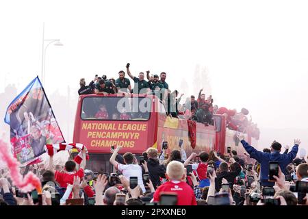 Fans celebrate with players who pass through the crowds on an open top ...