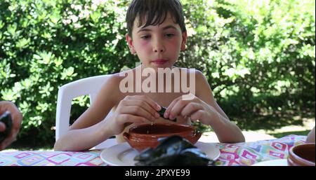 Children eating seafood mussel on bowl. Kids eaitng moules for lunch ...