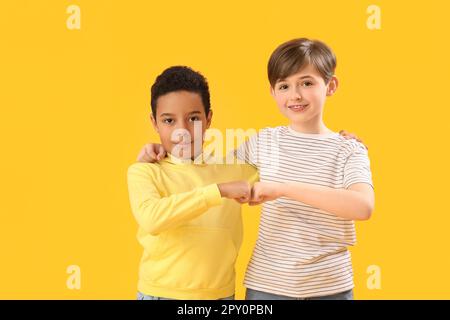 Little boys bumping fists on yellow background. Children's Day ...