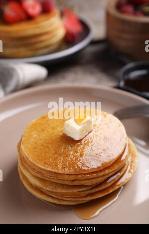 Stack of hot pancakes with melting honey on white plate with orange ...