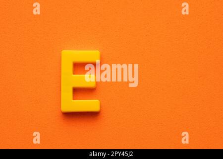 Yellow plastic letter I uppercase on orange foamy background Stock ...
