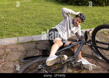 Man fallen off his bicycle in park Stock Photo - Alamy