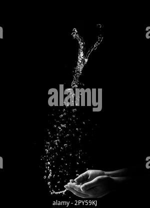 Woman's hands with water splash on black background Stock Photo - Alamy
