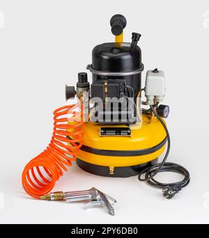 Yellow air compressor with orange tube in white back Stock Photo - Alamy