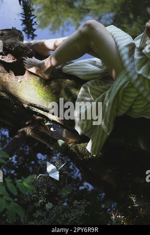 a beautiful woman posing on a log of an old tree in autumn, the colors ...