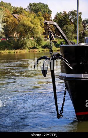 An anchor hangs from a chain on a barge Stock Photo - Alamy