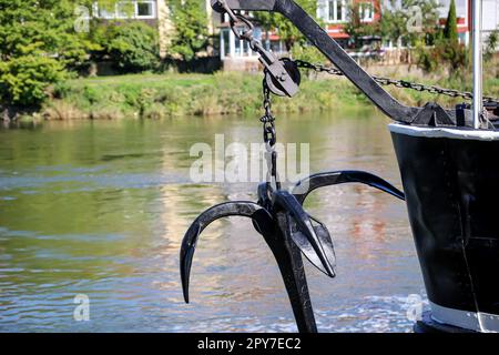 An anchor hangs from a chain on a barge Stock Photo - Alamy