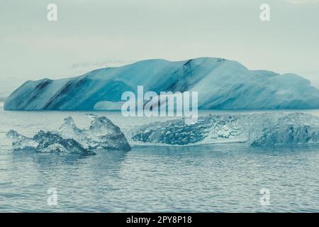 Ice pieces floating in the ocean. Mountains reflected in the icy waters ...