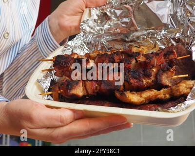 Grilled meat in disposable packaging and aluminum foil, delivered from ...
