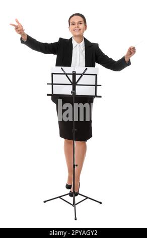 Happy young conductor with baton and note stand on white background ...