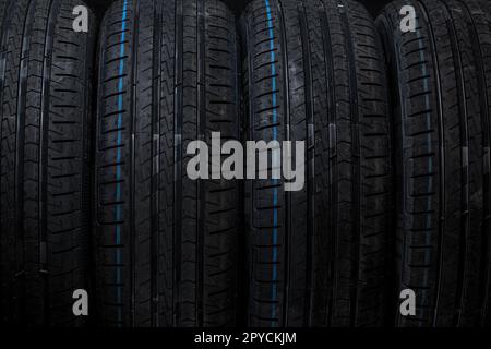 Stack of brand new high performance car tires on clean high-key white ...