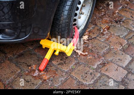A car is prevented from moving forward by a parking claw, tire claw ...