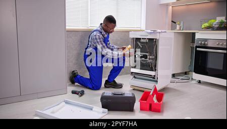African American Repairman Fixing Dishwasher Appliance Stock Photo - Alamy