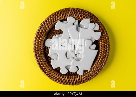 White jigsaw puzzle in container under yellow background Stock Photo ...