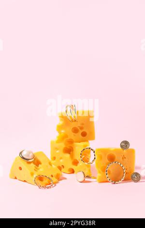 Cheese with stylish golden rings on pink background with space for text ...