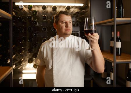 Successful male sommelier tasting flavor and checking wine quality ...