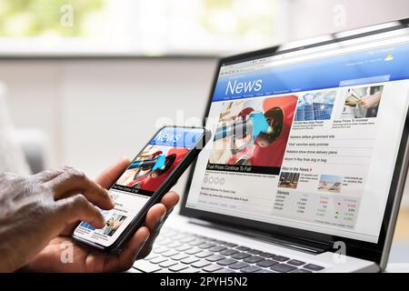 Watching Online News Article On Mobile Phone And Laptop. Electronic ...