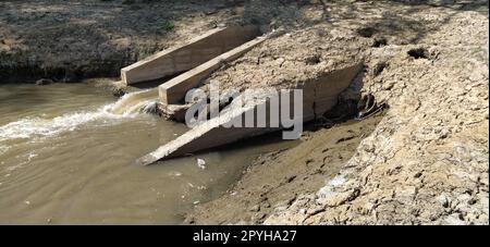 A large city drain drains sewage into a canal that flows into the river ...