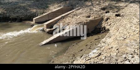 A large city drain drains sewage into a canal that flows into the river ...