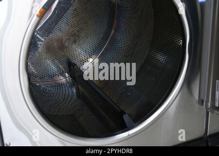 a stainless steel washing machine drum filled with colorful laundry ...