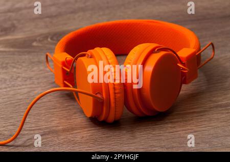 Modern orange headset headphones on the table Stock Photo - Alamy