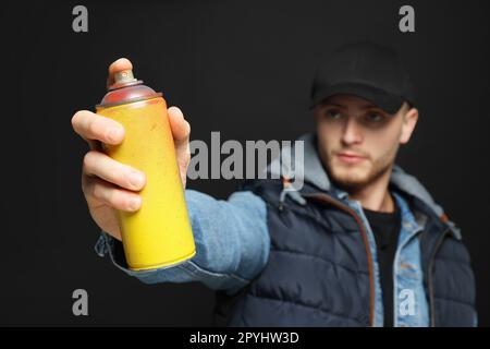 Man holding spray paint against white background, back view Stock Photo ...