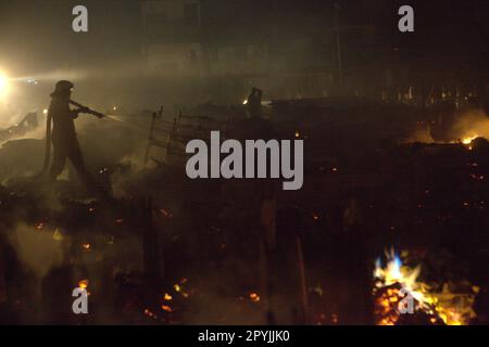 A firefighter performing the cooling phase after a fire accident burned ...