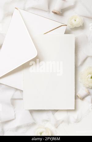 Wedding Card near white silk ribbons on light yellow top view, mockup ...